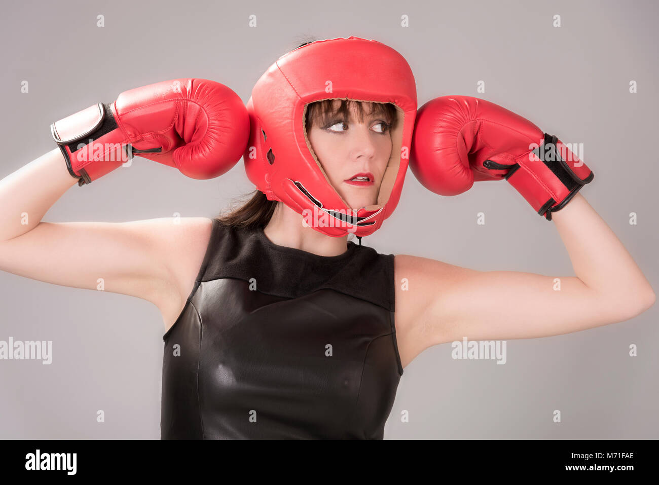 Woman boxer with an facial expression wearing a red headguard and red ...