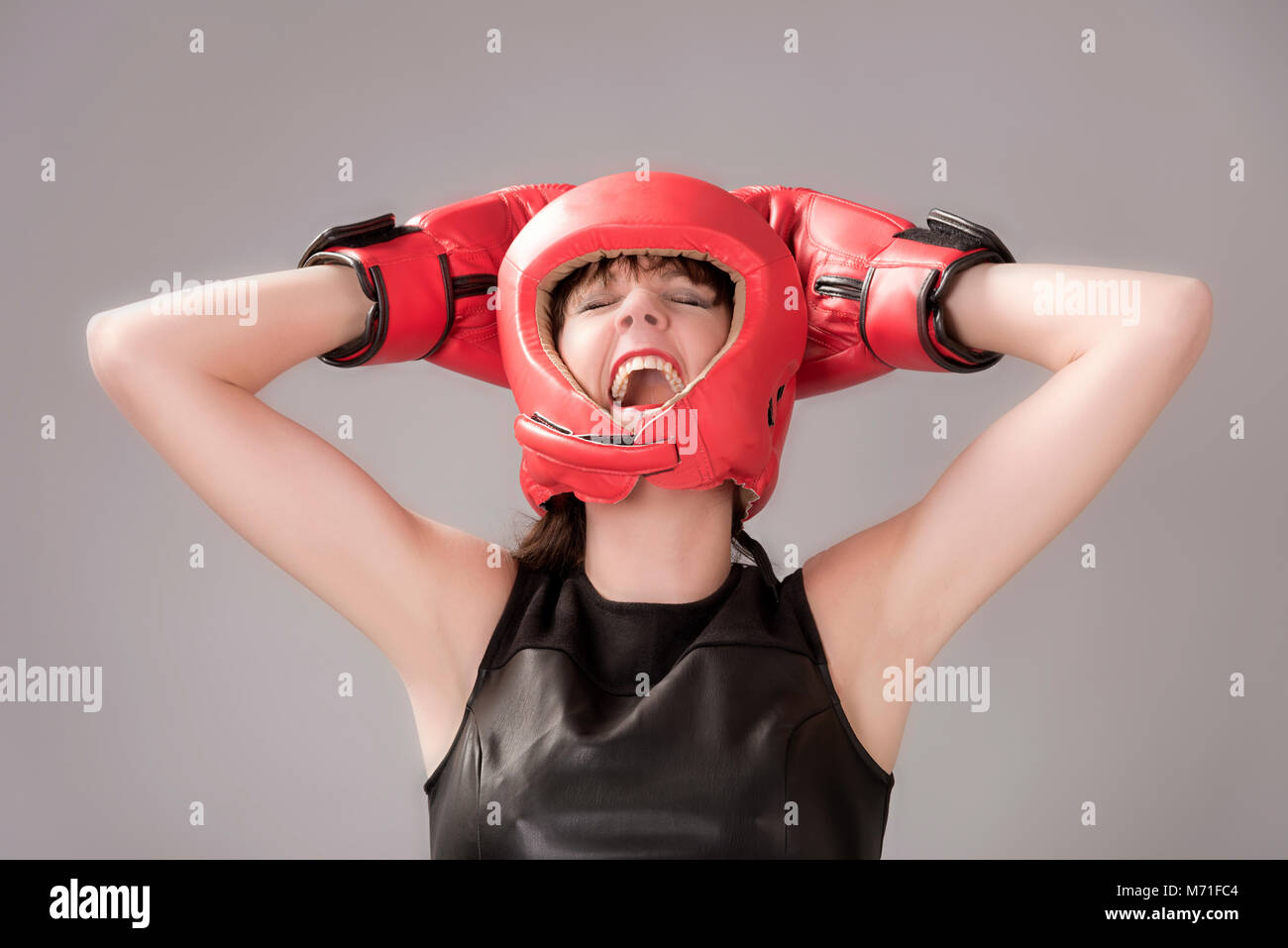 Woman boxer with an facial expression wearing a red headguard and red ...