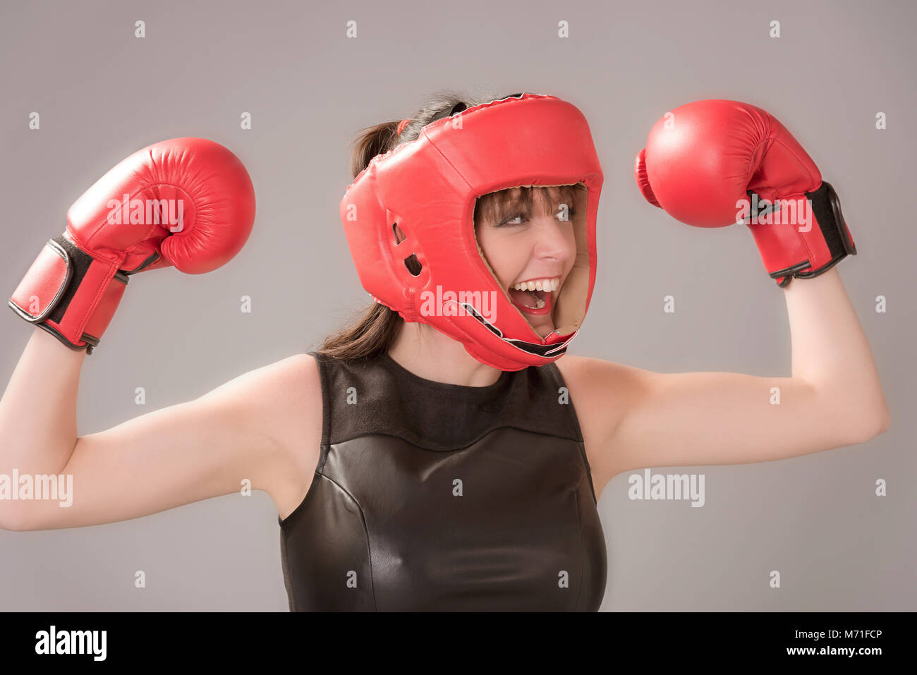 Woman boxer with an facial expression wearing a red headguard and red ...