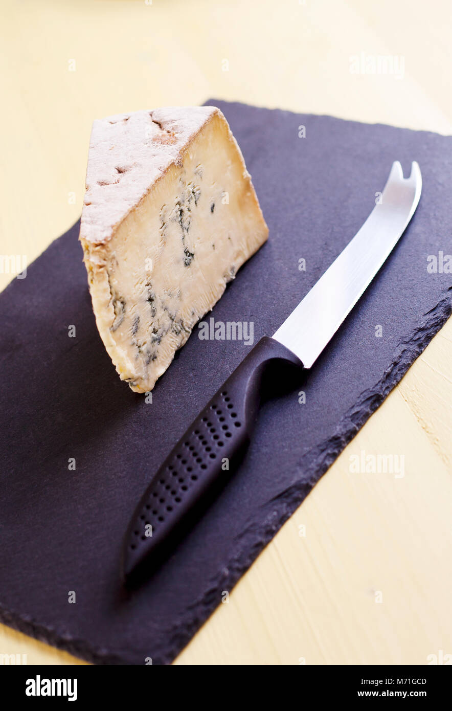 A segment of blue veined Stilton Cheese on Slate Platter Stock Photo ...