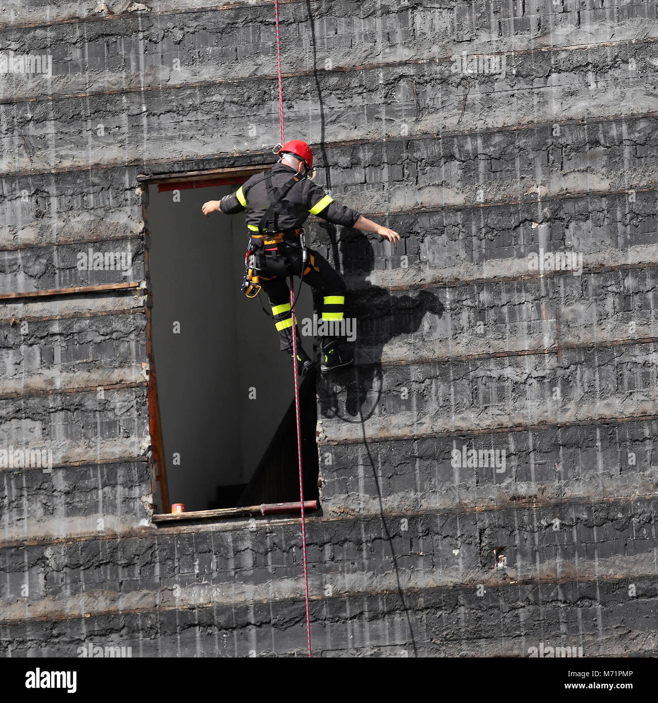 firefighter climbing a wall of a house during the fire drill Stock ...