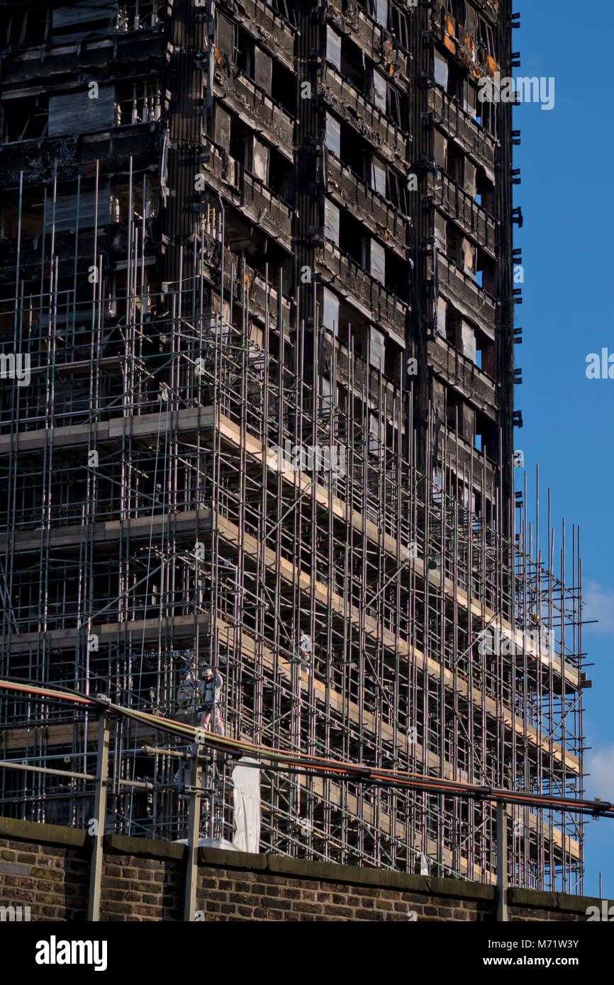 Construction workers building scaffolding before demolition of burnt ...