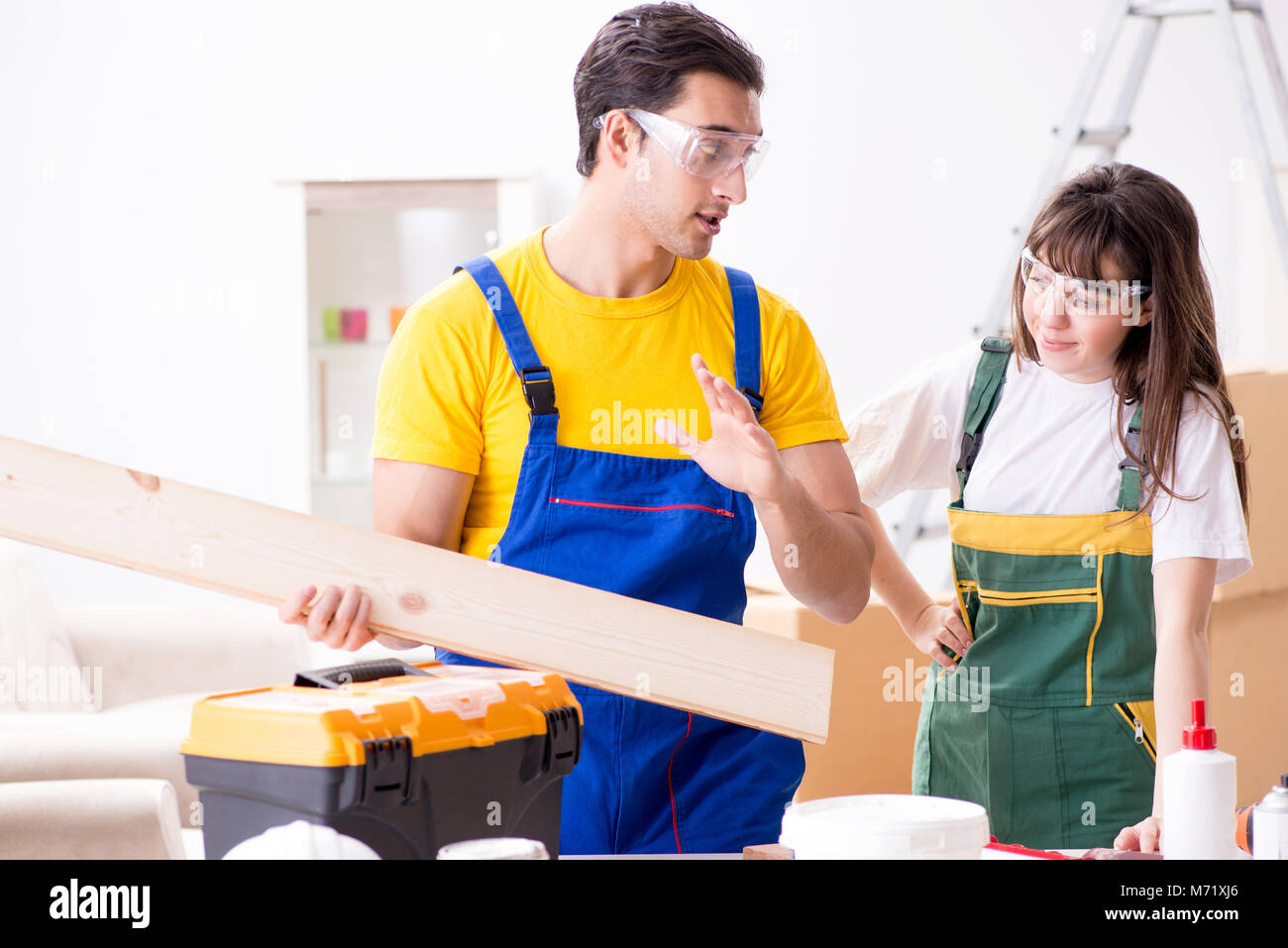 Man explaining woman woodworking tips in wood workshop Stock Photo - Alamy