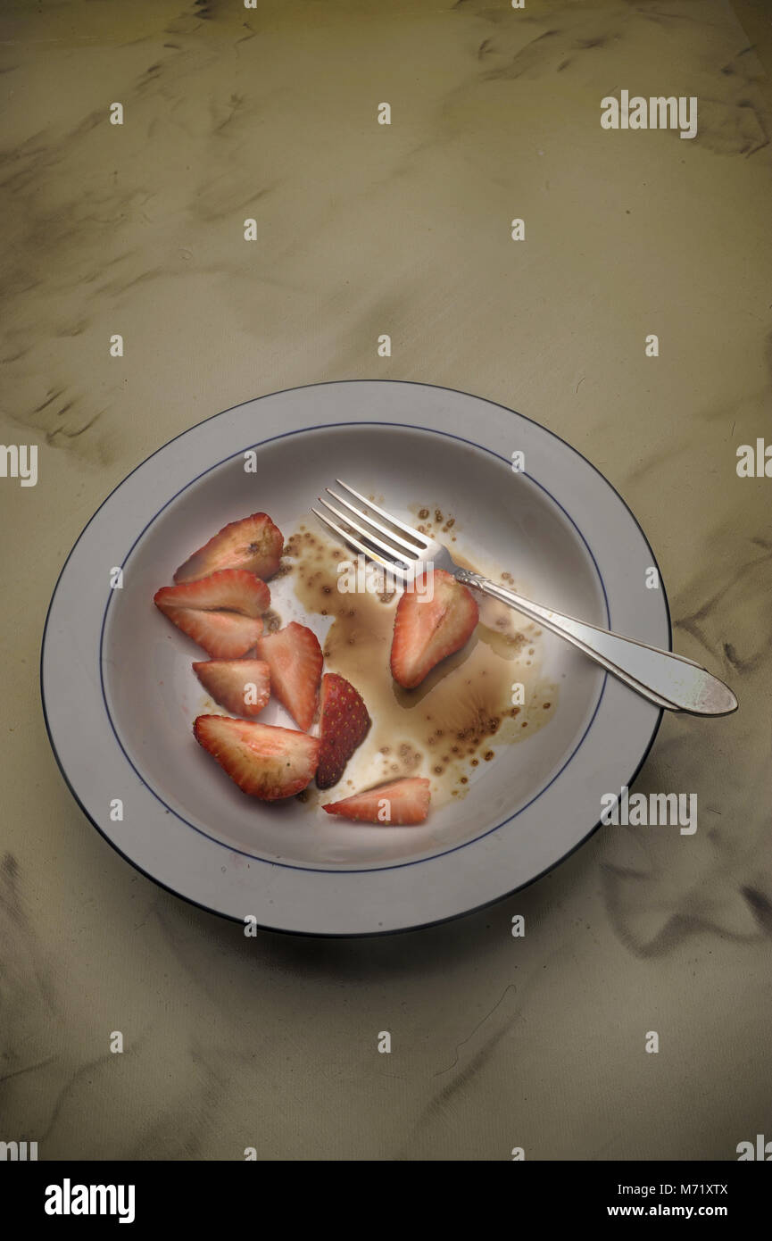 strawberries on a plate with a marble background cut in quarters with ...