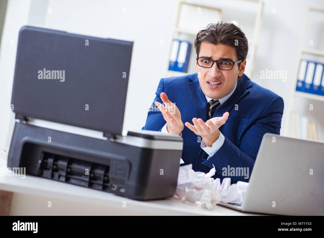 Businessman angry at copying machine jamming papers Stock Photo - Alamy