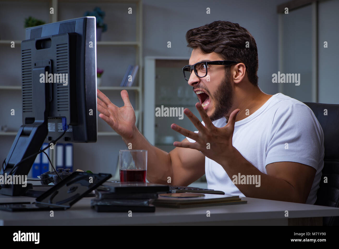 Young man staying late in office to do overtime work Stock Photo - Alamy