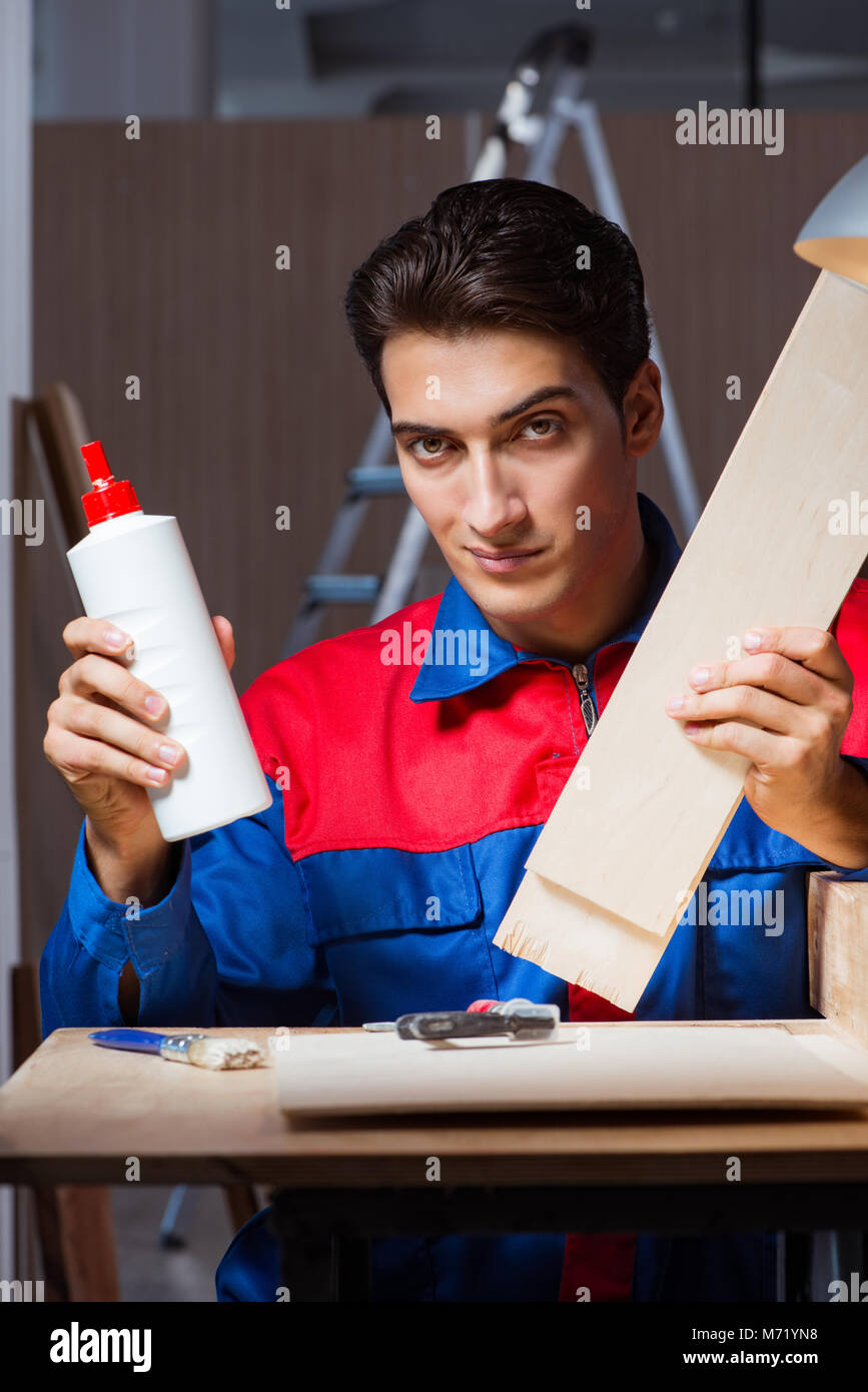 Young man gluing wood pieces together in DIY concept Stock Photo - Alamy