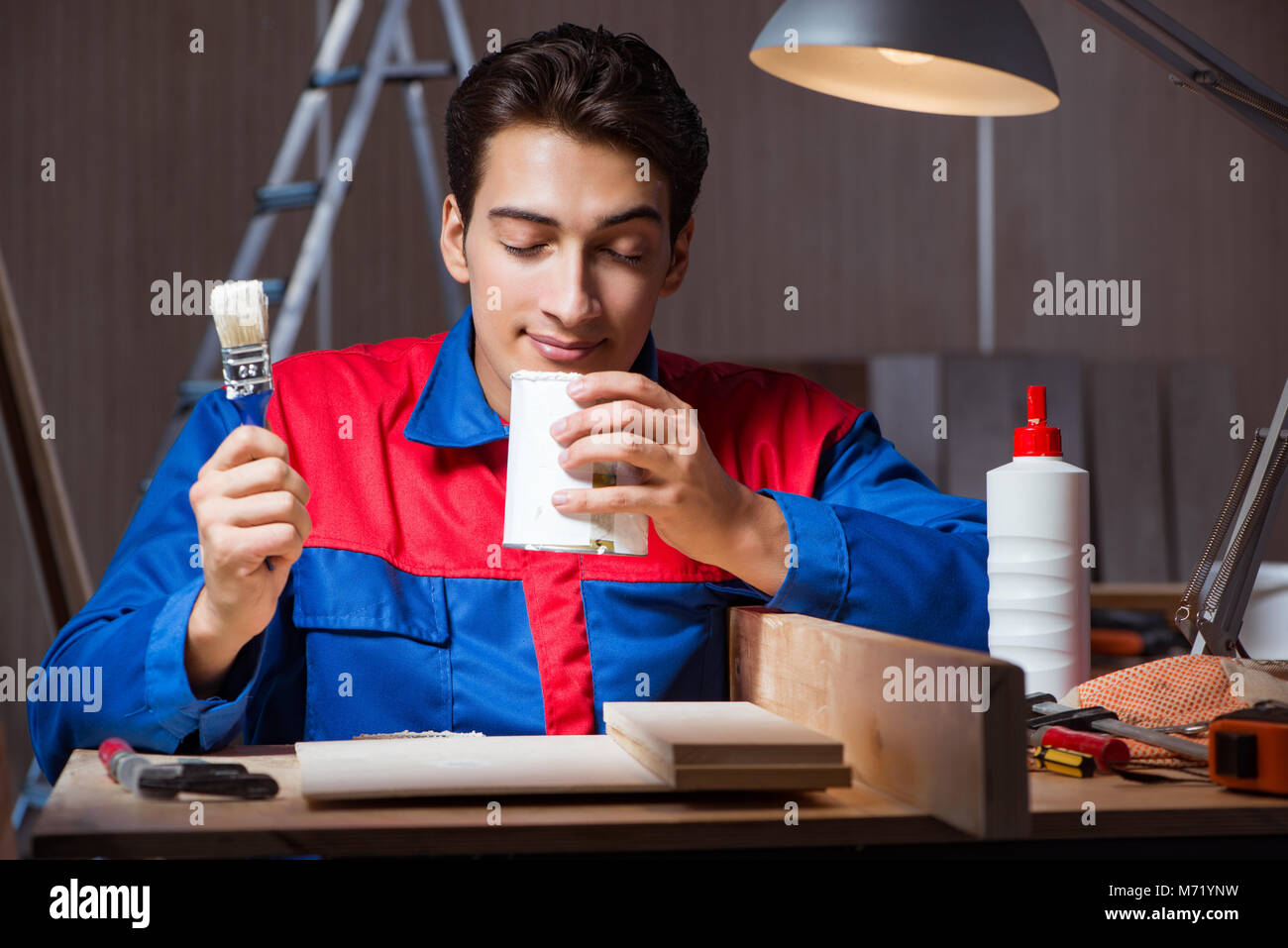 Young man gluing wood pieces together in DIY concept Stock Photo - Alamy