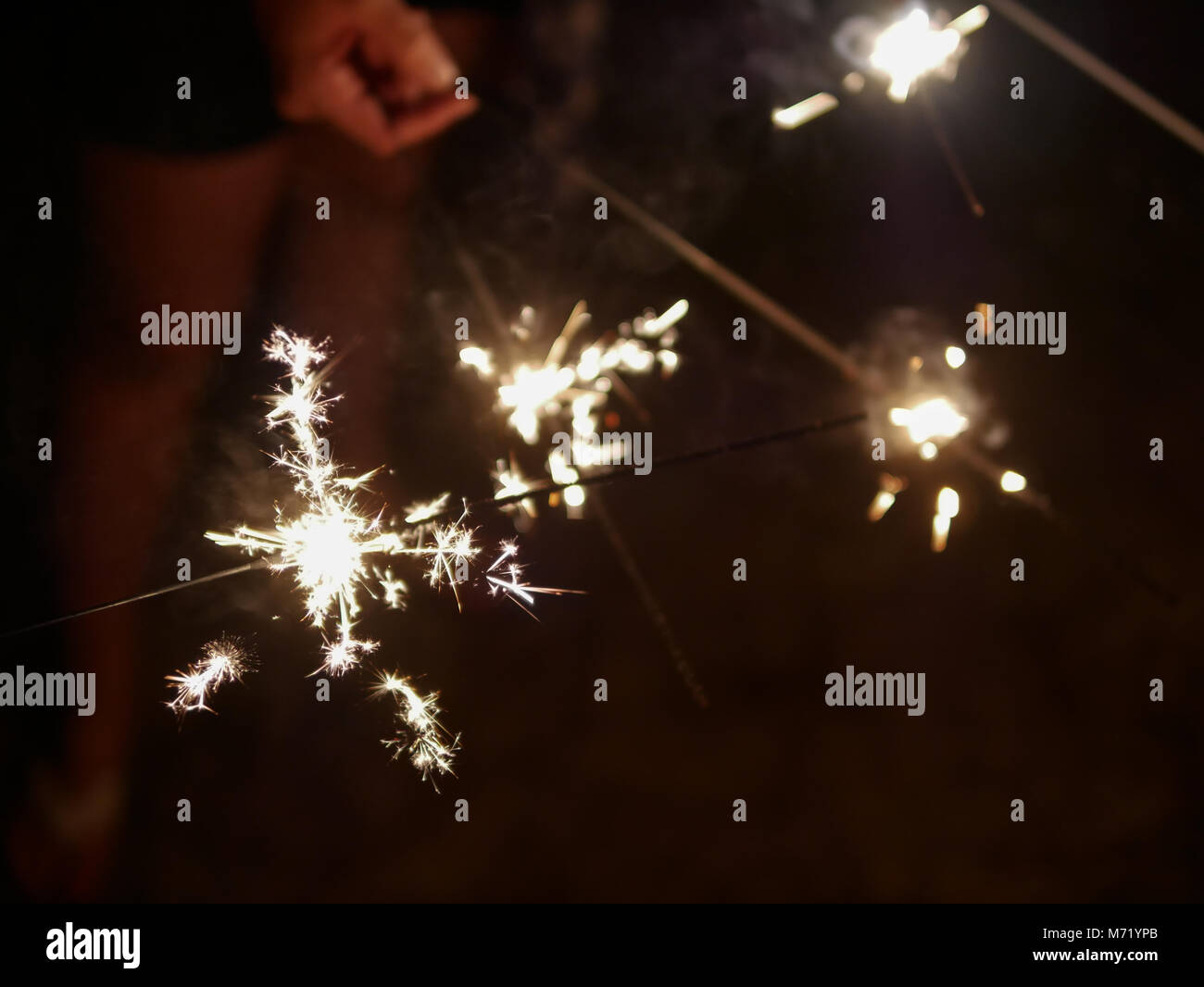 Close up of people holding firework sparklers Stock Photo - Alamy