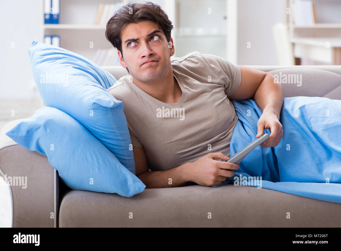 Man watching tv from bed holding remote control unit Stock Photo - Alamy