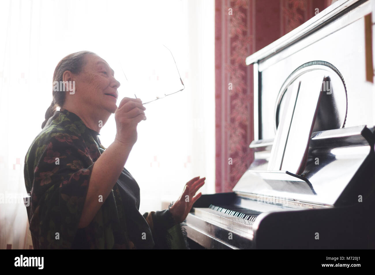 The old lady sitting in front of a piano and singing a song Stock Photo ...