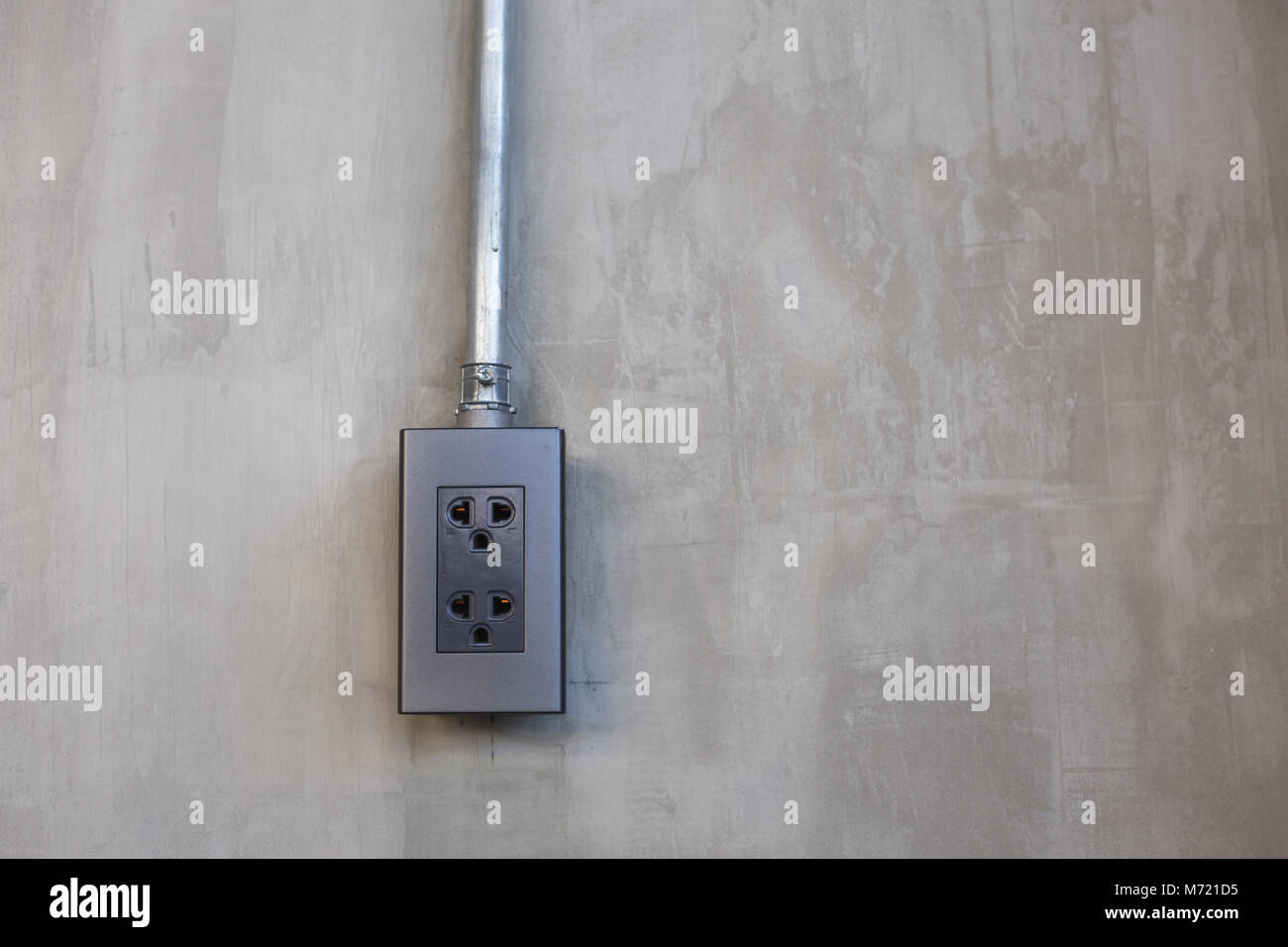 Electric socket for power on concrete loft style wall Stock Photo - Alamy
