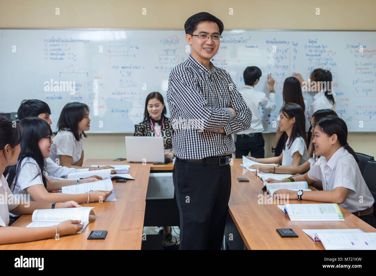 Portrait of Asian teacher standing when Giving Lesson to group of ...