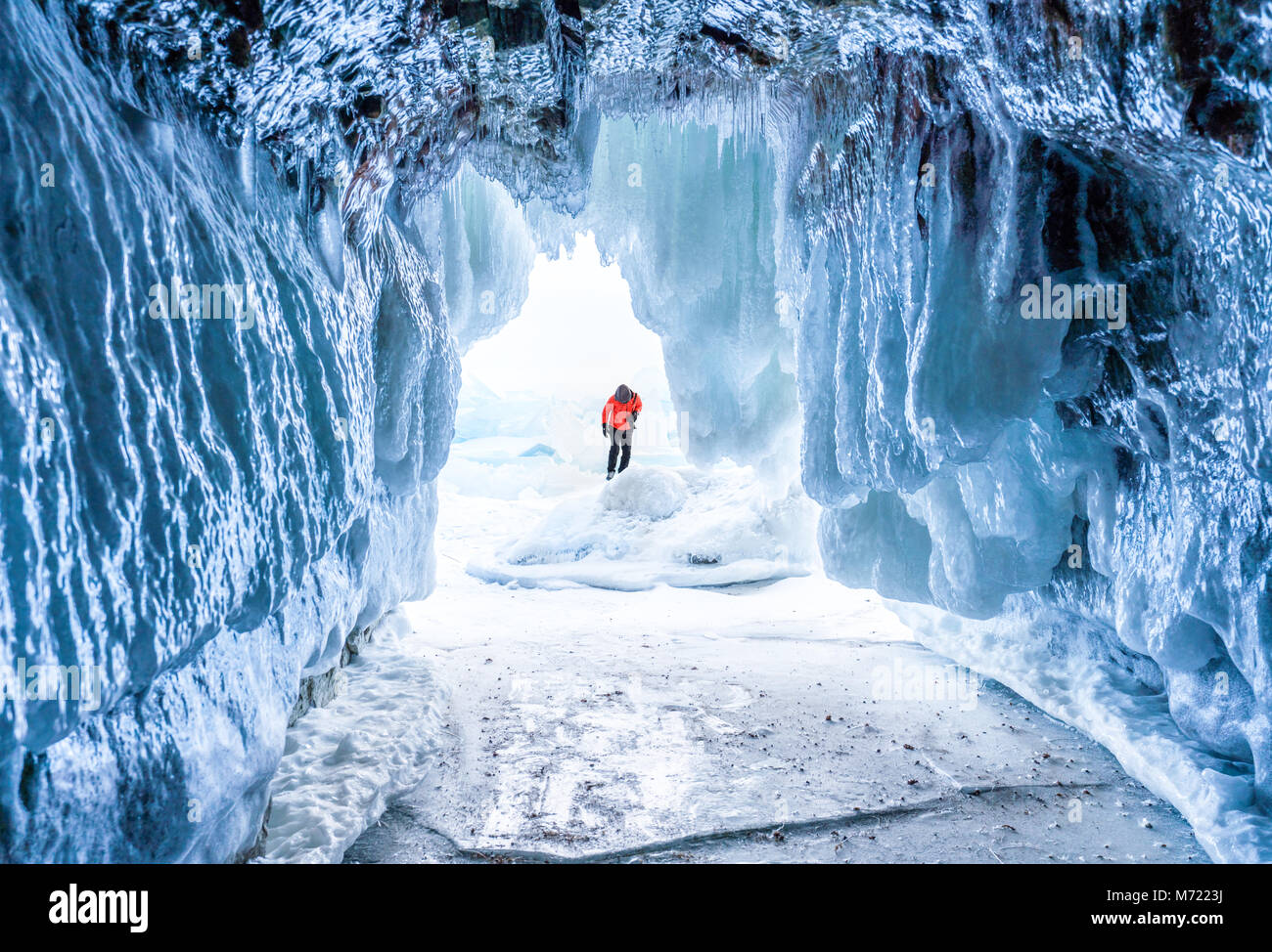 Winter Landscape, Frozen ice cave with young photographer standing ...