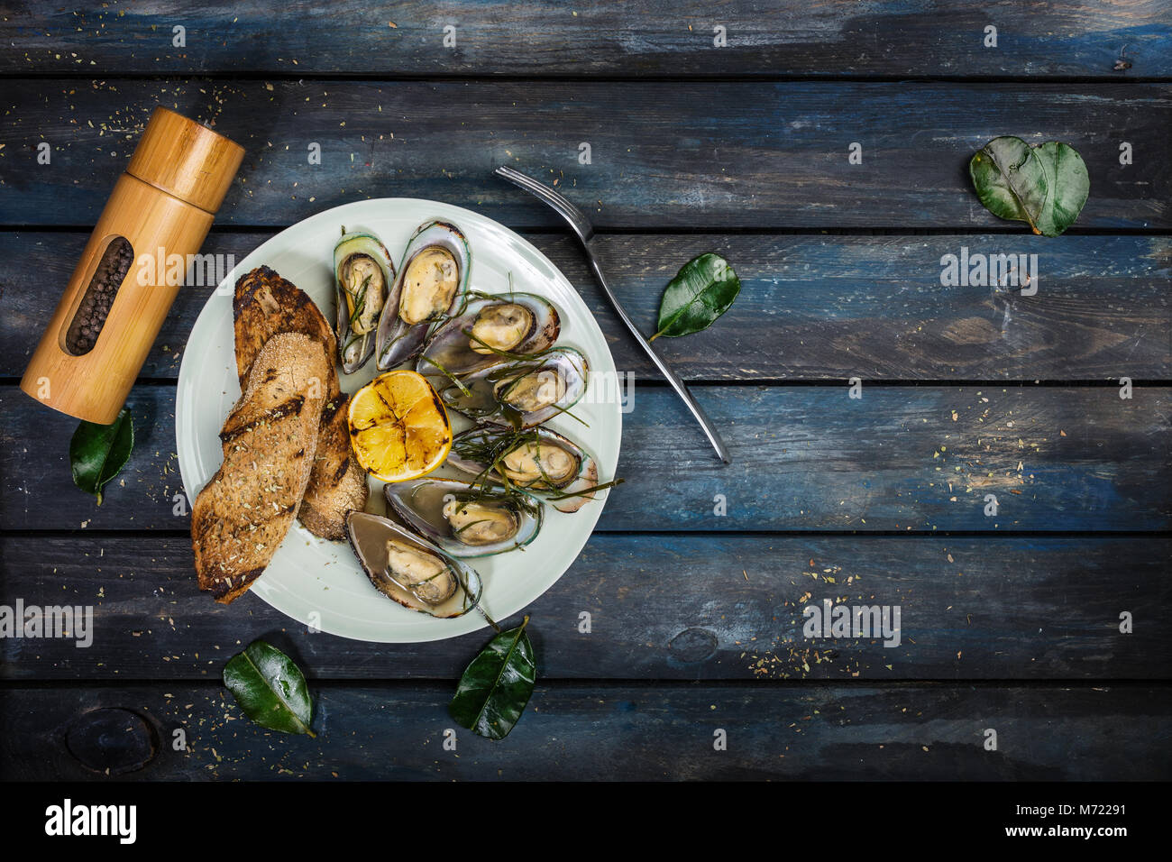 Mussels and bread toasts on on a white plate. Top view Stock Photo - Alamy