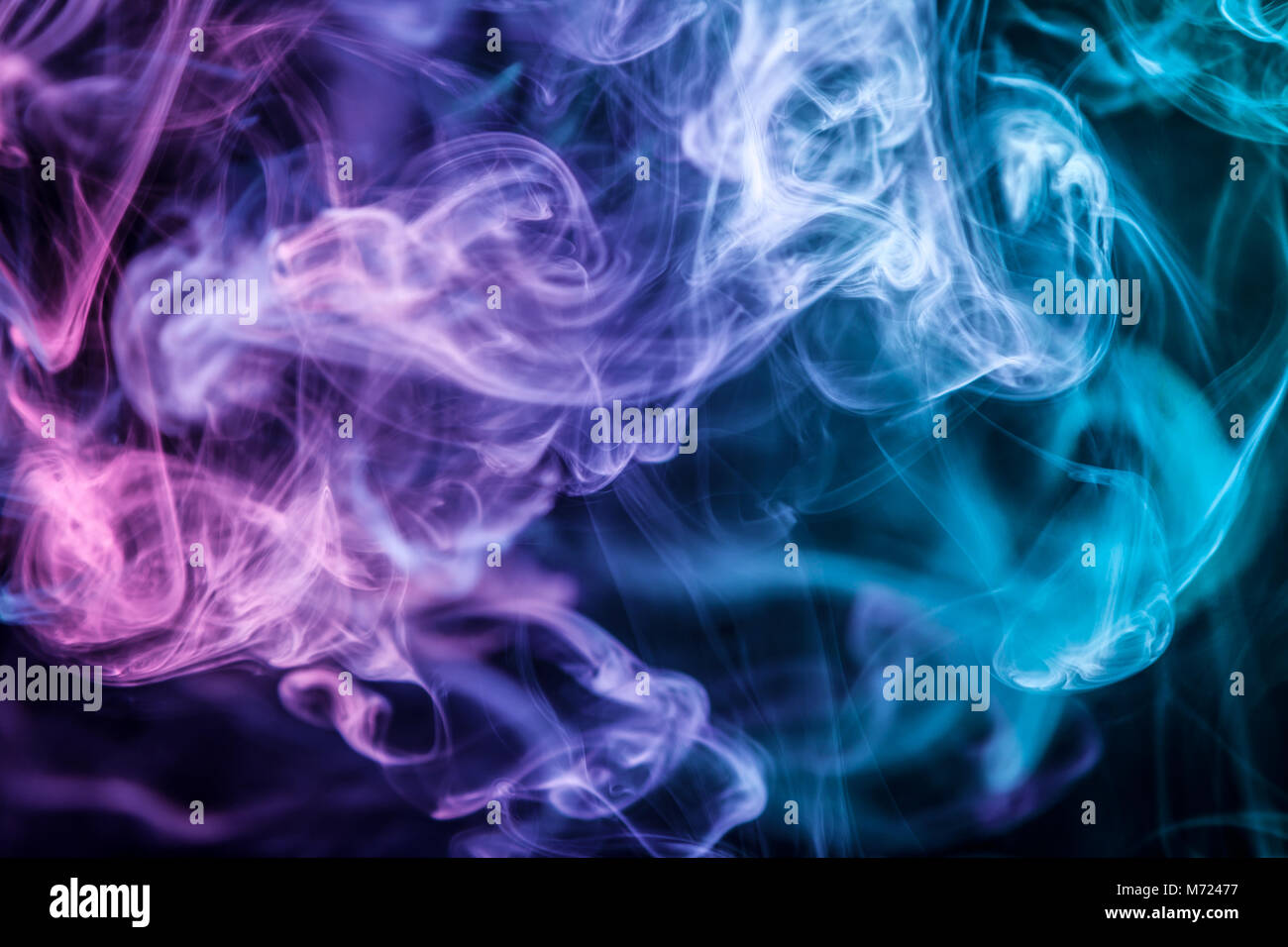 Dense multicolored smoke of blue and pink colors on a black isolated ...