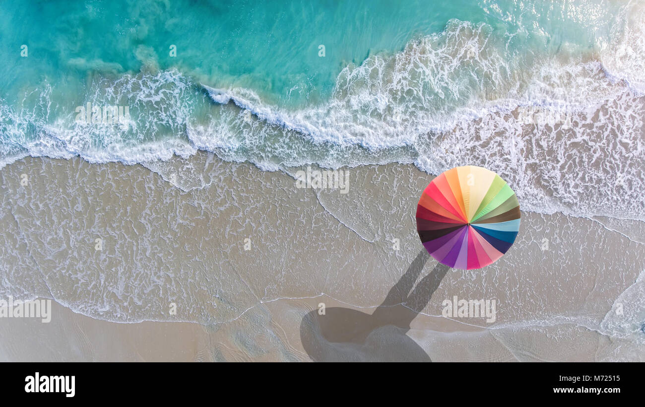 Colorful of umbrella on the beach and foam of sea wave from top eye ...