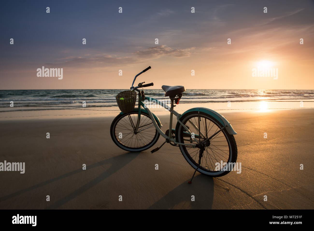 Seascape in sun set time with the bicycle on the beach photo with ...
