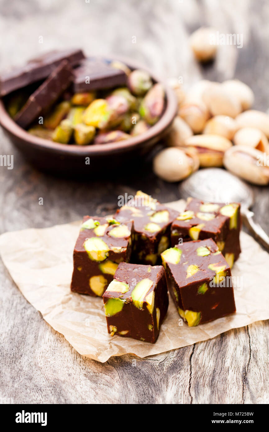 Dark chocolate cubes with pistachios on wooden background Stock Photo ...