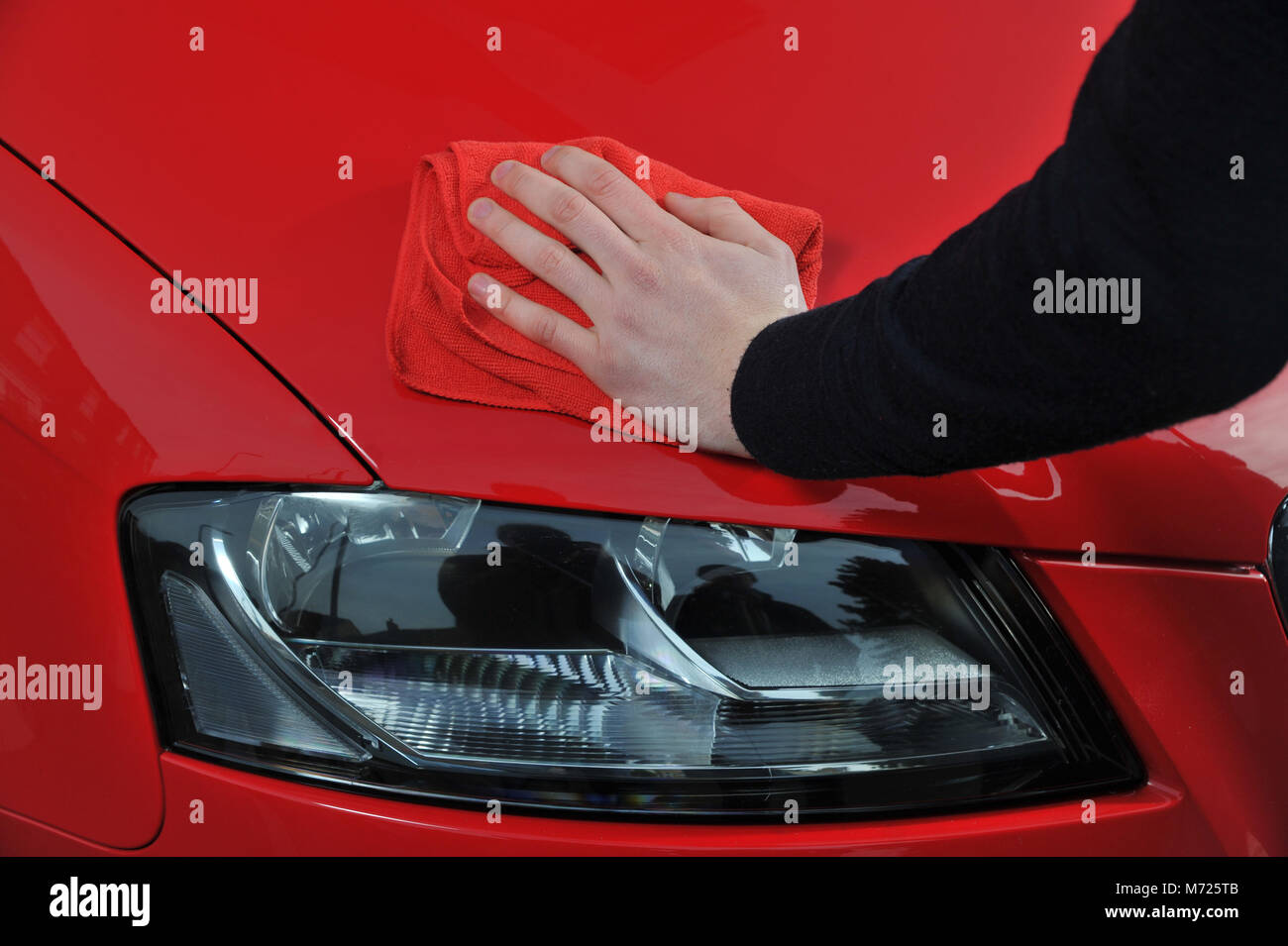 Polishing a red car with a red cloth Stock Photo - Alamy