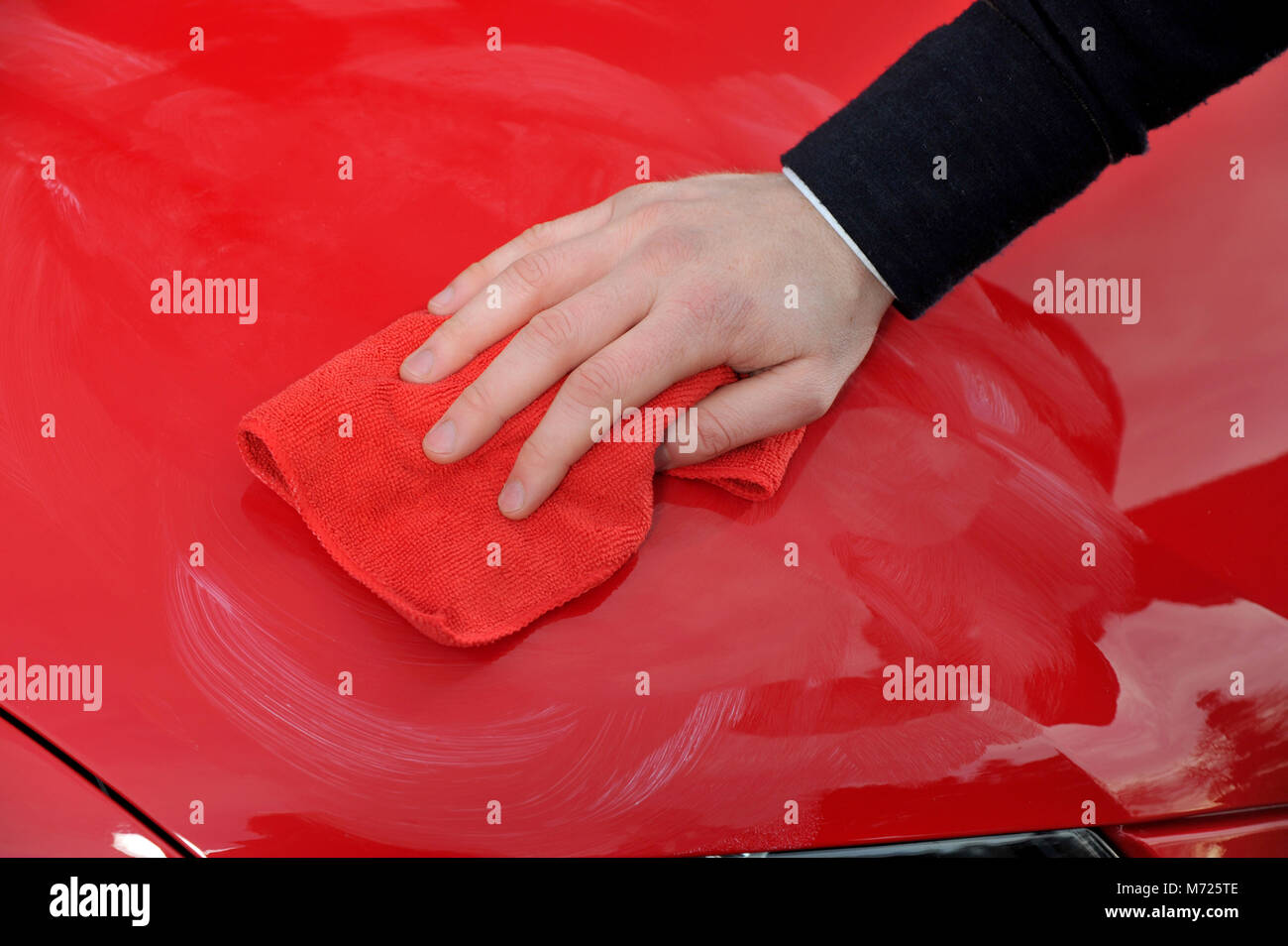 Polishing a red car with a red cloth Stock Photo - Alamy
