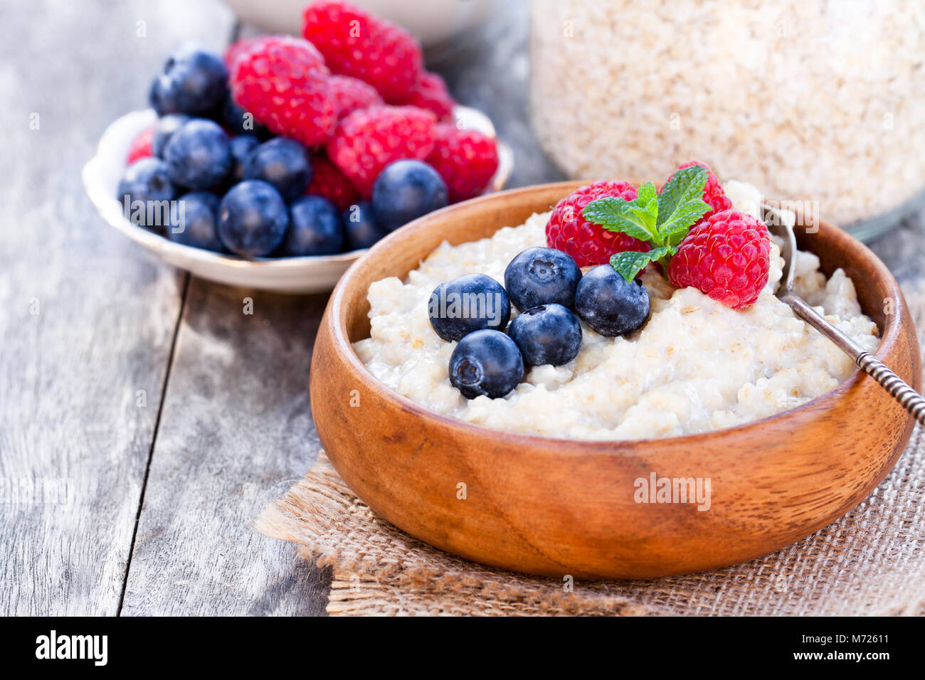 Porridge in a wooden bowl with berries Stock Photo - Alamy