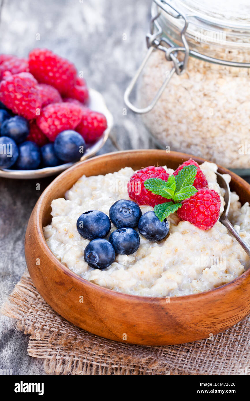 Porridge in a wooden bowl with berries Stock Photo - Alamy
