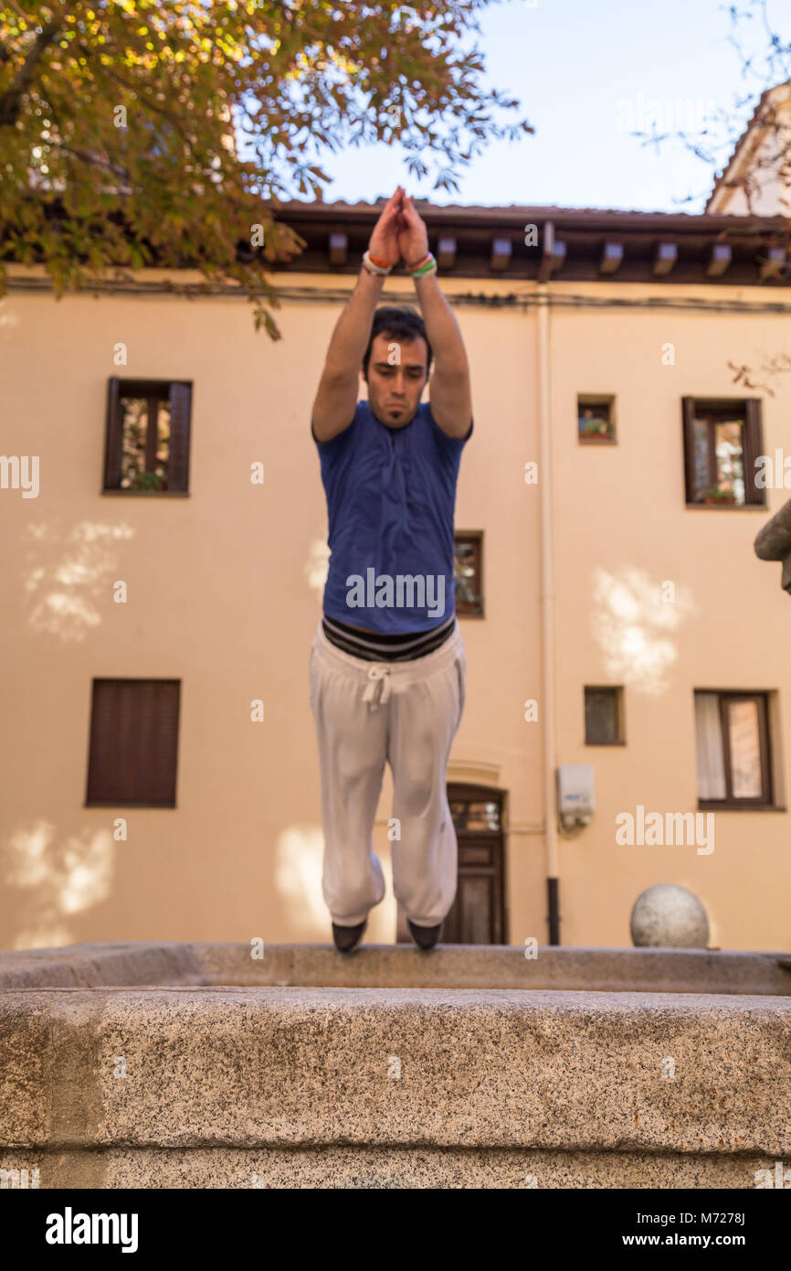 Young man doing an awesome parkour jump on the street Stock Photo - Alamy