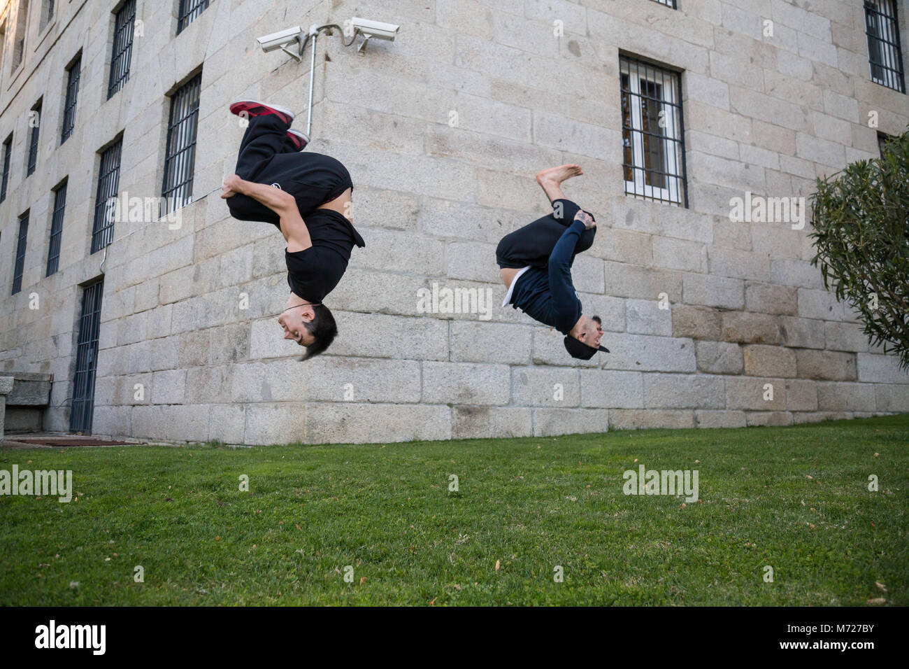 Two young men doing a side flip or somersault while they practicing ...