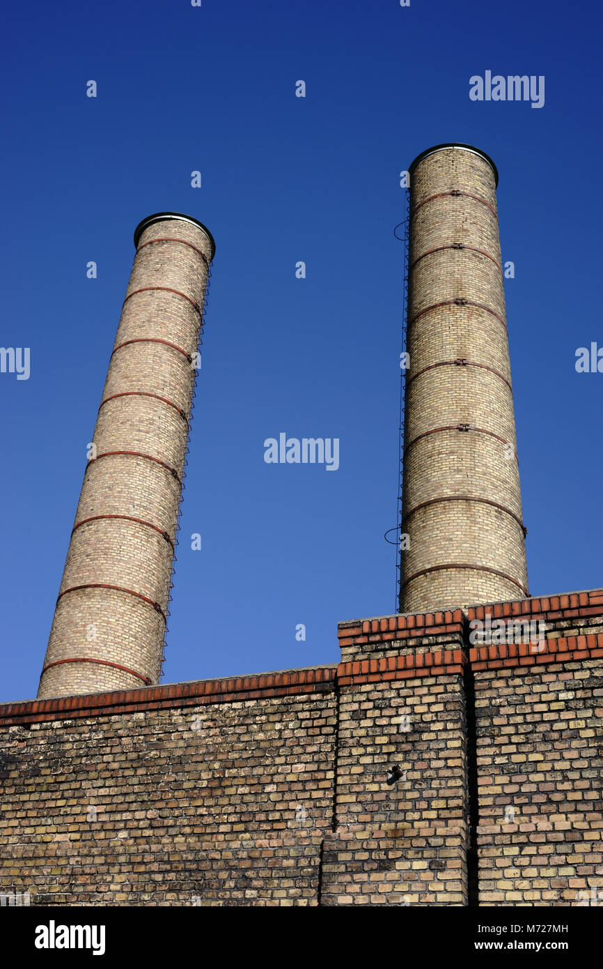 The disused chimneys of a factory with brick industrial buildings Stock ...