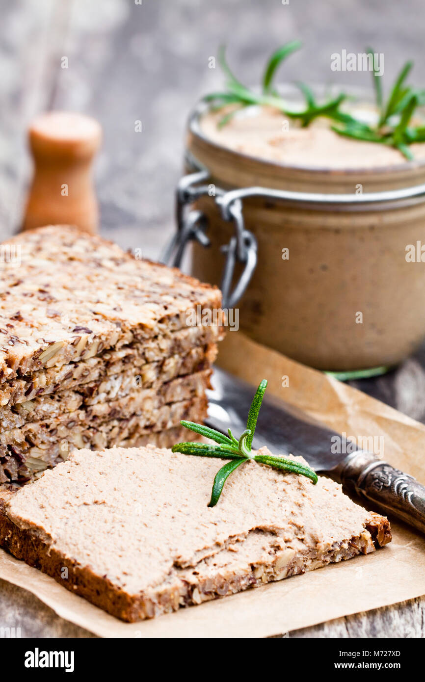 homemadeliver pate with rosemary in a jar on a rustic wooden table ...