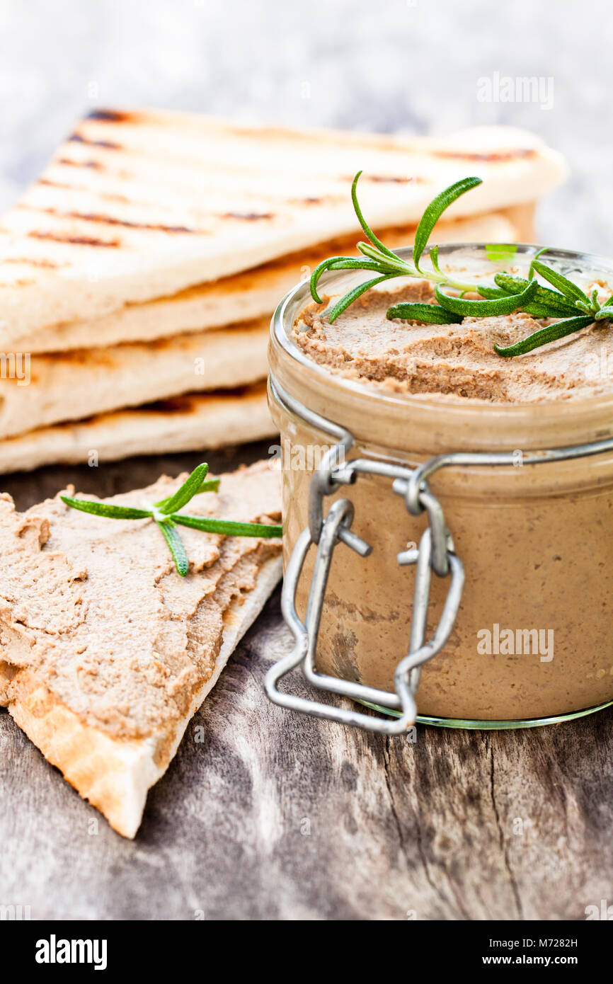 homemadeliver pate with rosemary in a jar on a rustic wooden table ...