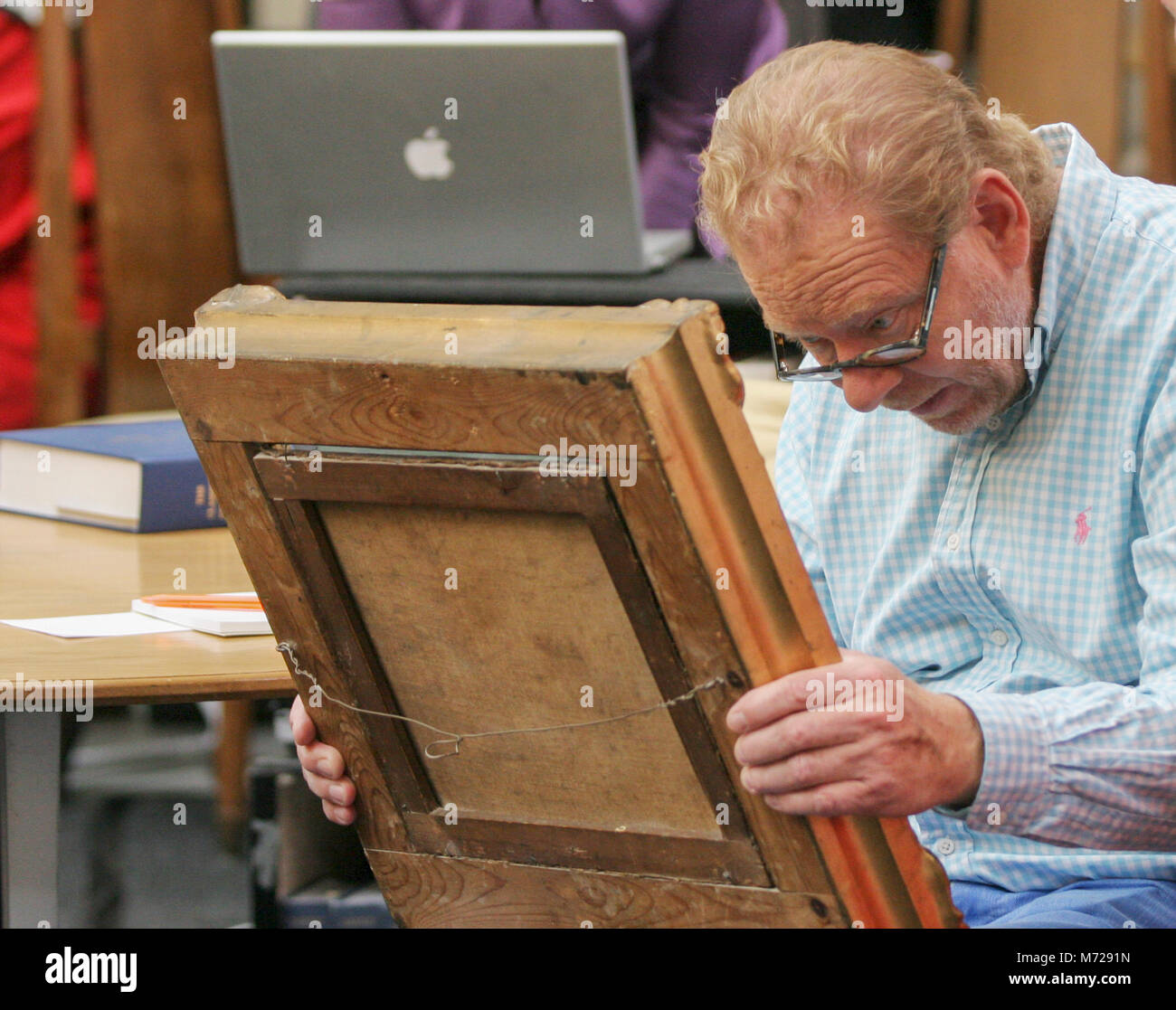 ART EXPERT studies the painting for evaluation 2014 Stock Photo - Alamy