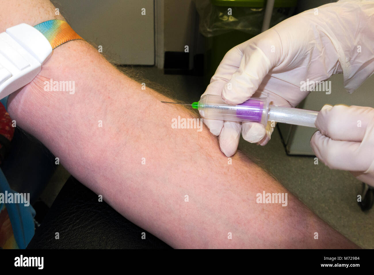 Blood test being performed on a middle aged man's arm / / blood being ...