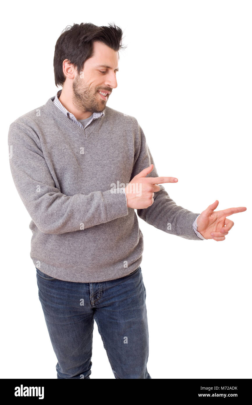 friendly young man pointing to his side and looking into the camera ...