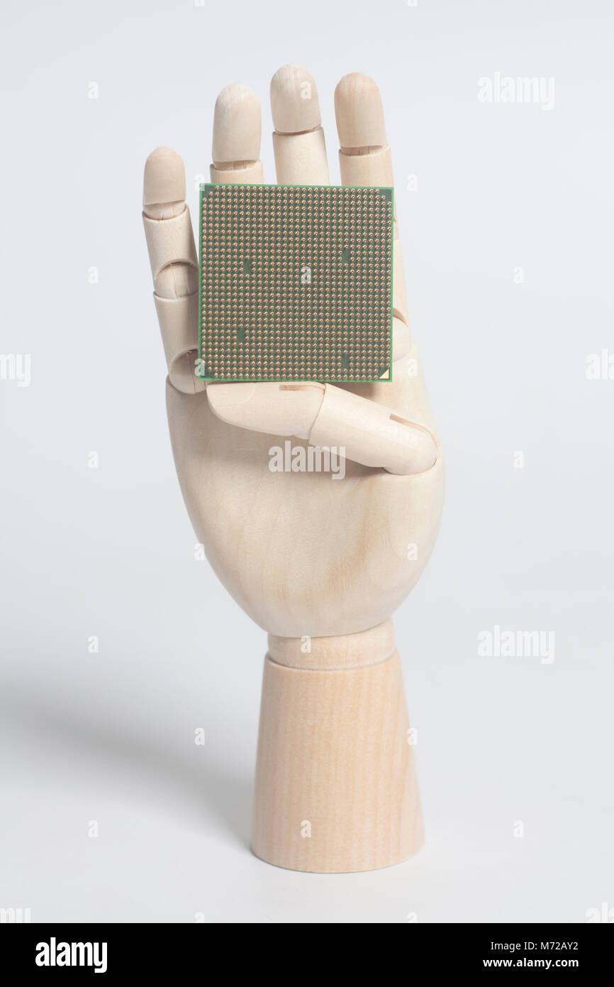 Wooden robot hand holding central processing unit CPU microchip on ...
