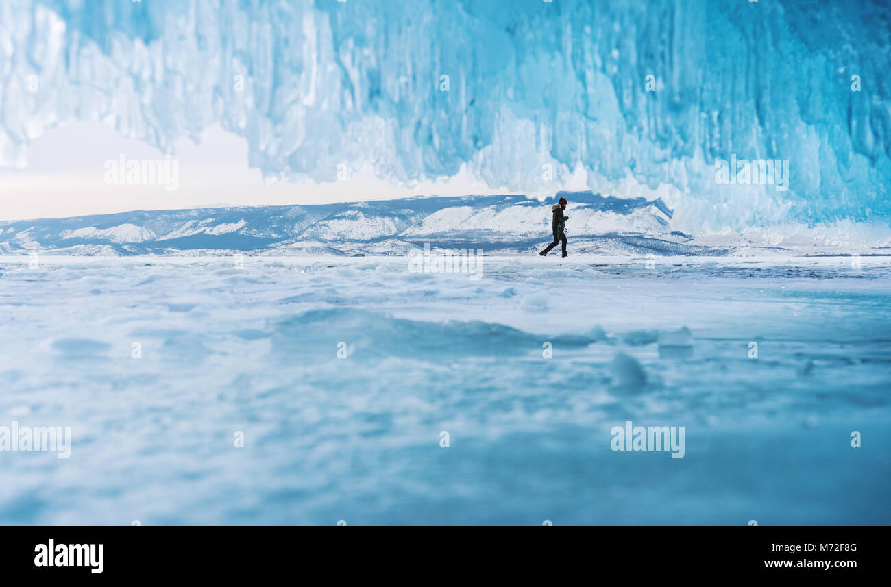 Winter landscape, snow on the floor with ice and a man walking alone ...