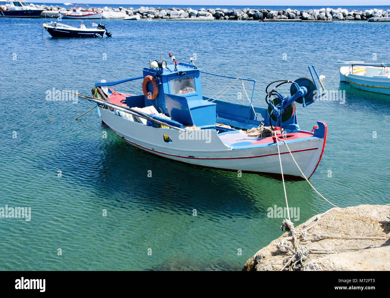 Small fishing wooden boat,floating in clear waters Stock Photo - Alamy