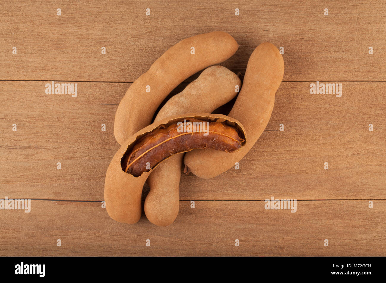 Top view tamarind pod on wood background Stock Photo - Alamy