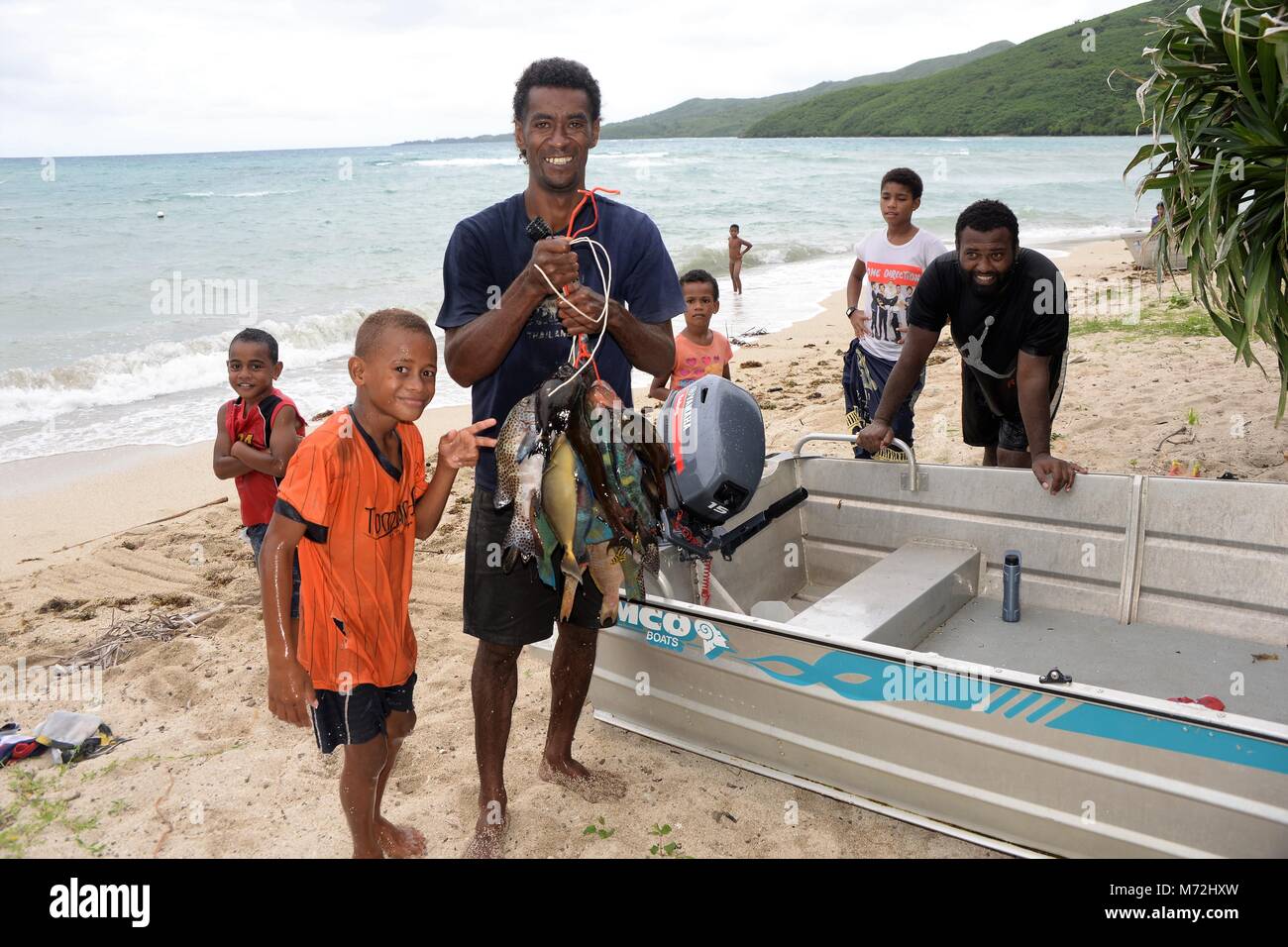 Native Fijian children enjoy watching the fish arrive on the beach on a ...