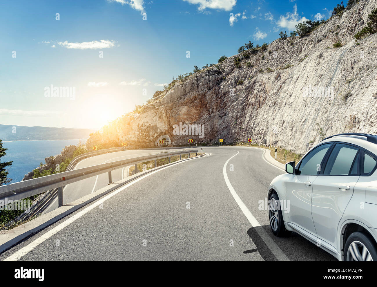 A white car rushing along a high-speed highway in the sun Stock Photo ...