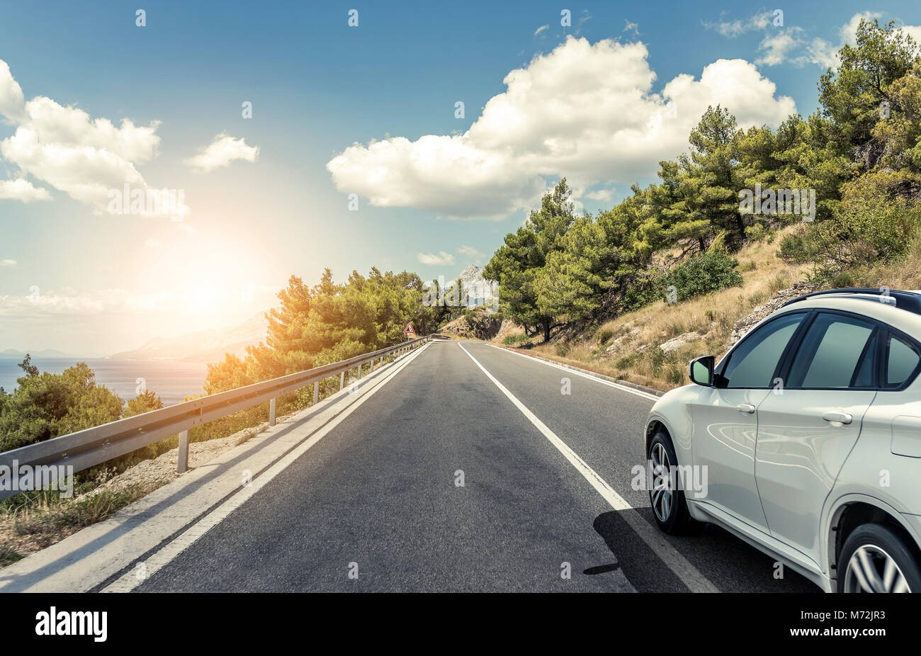 A white car rushing along a high-speed highway in the sun Stock Photo ...