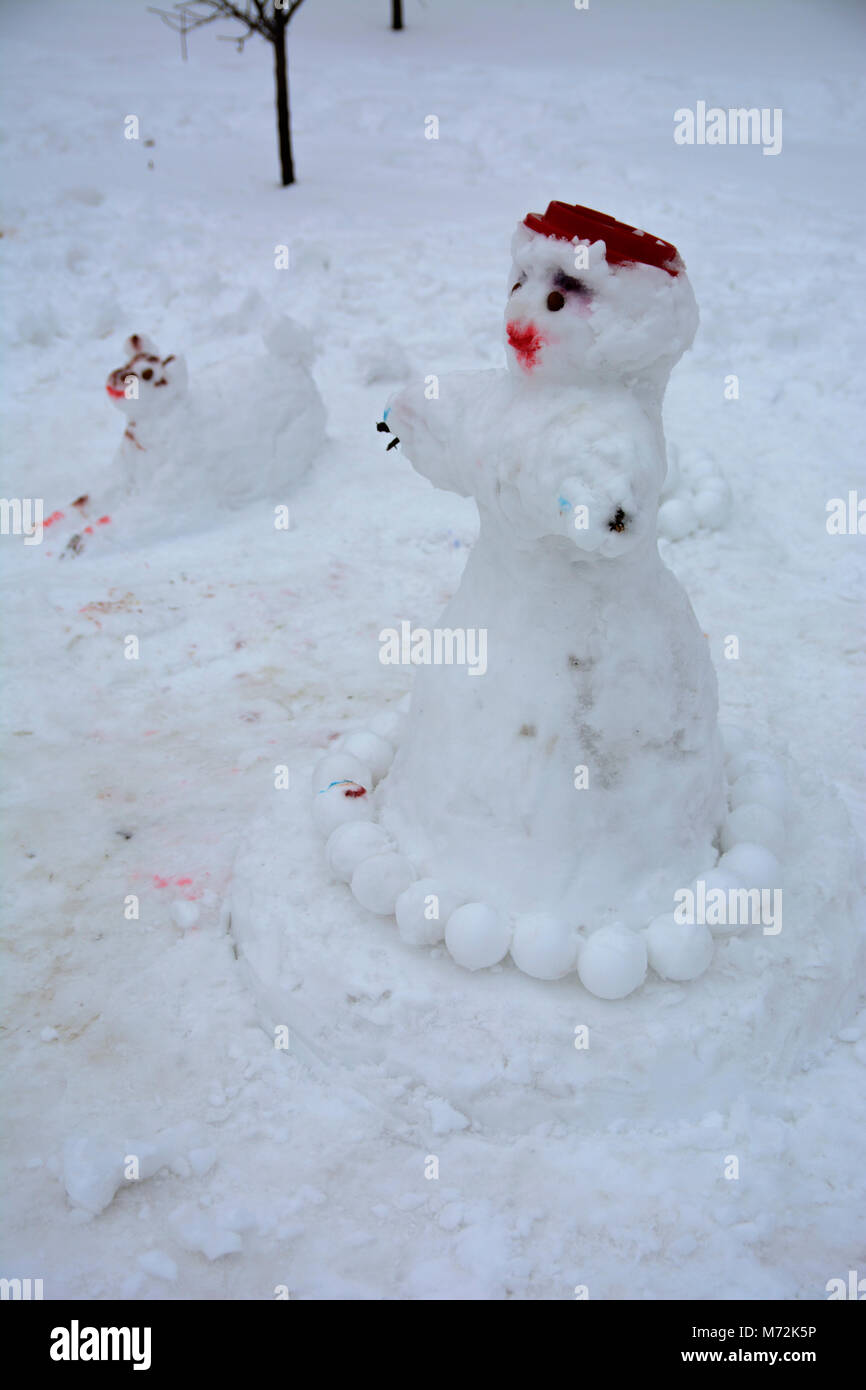 A terrible ugly snowman sculpted from the snow by children against the ...