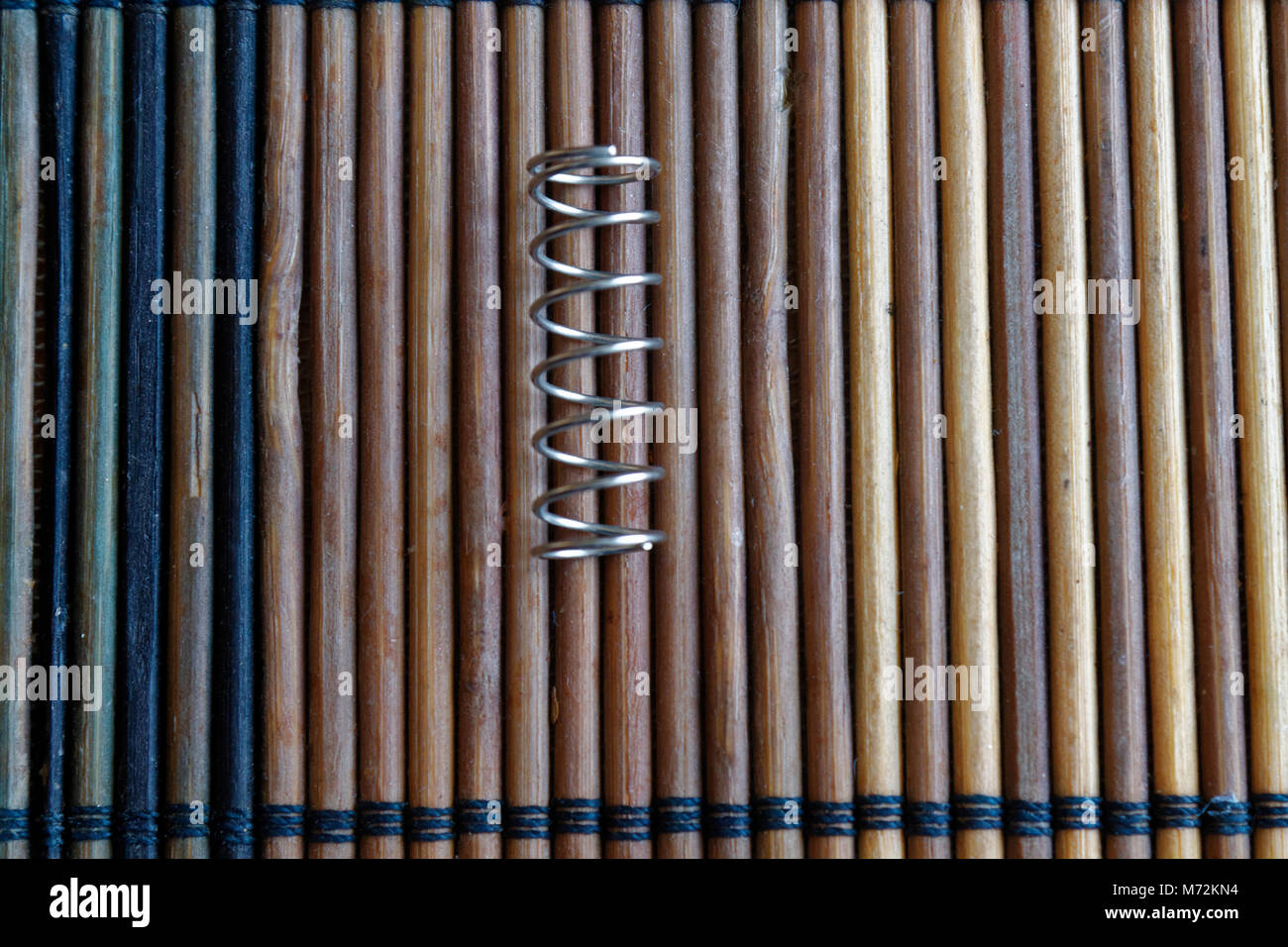 Steel spring with hooks on wooden background Stock Photo - Alamy