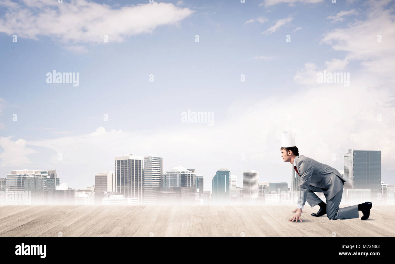 Young handsome businessman wearing white paper crown running in a hurry ...