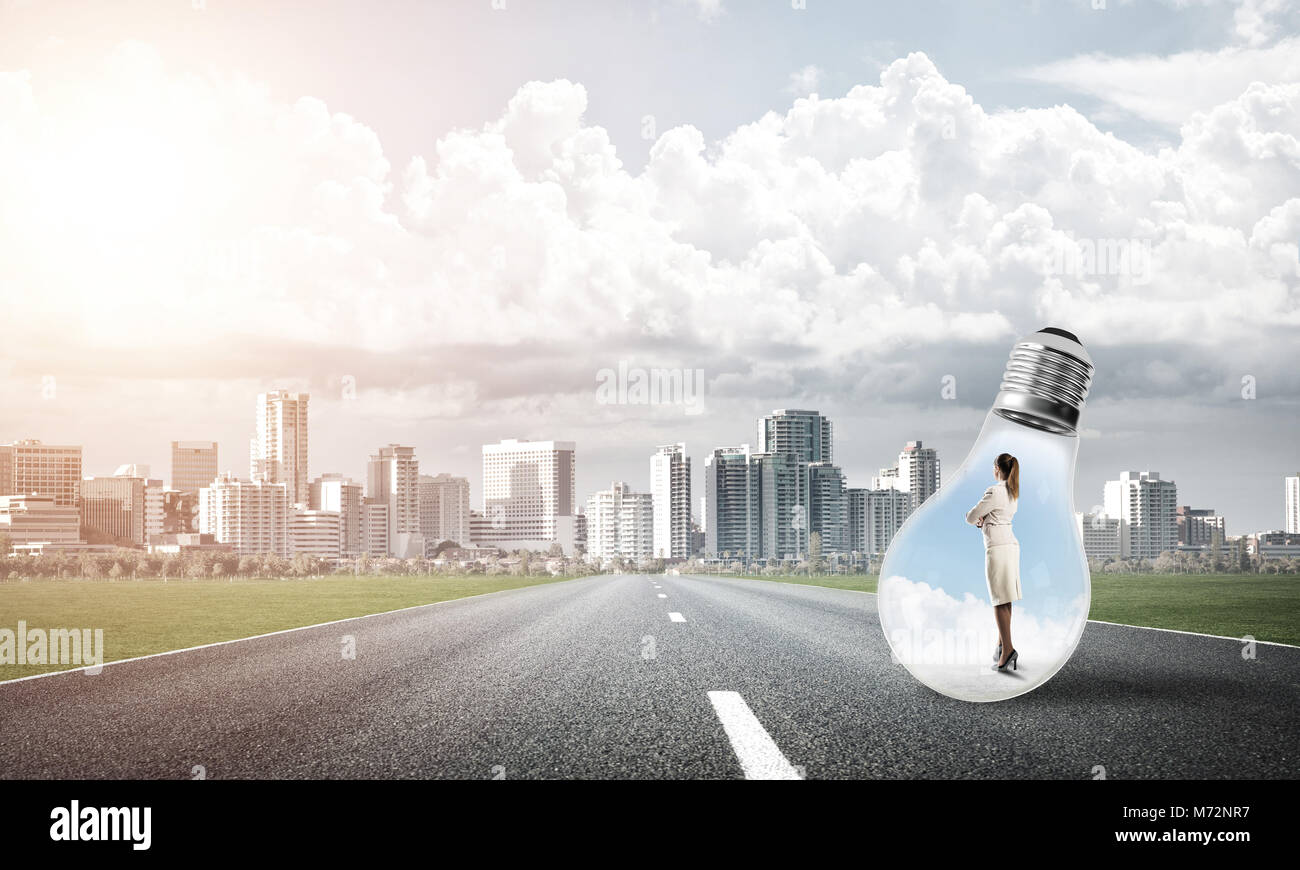 Young businesswoman trapped inside of light bulb on asphalt road Stock ...