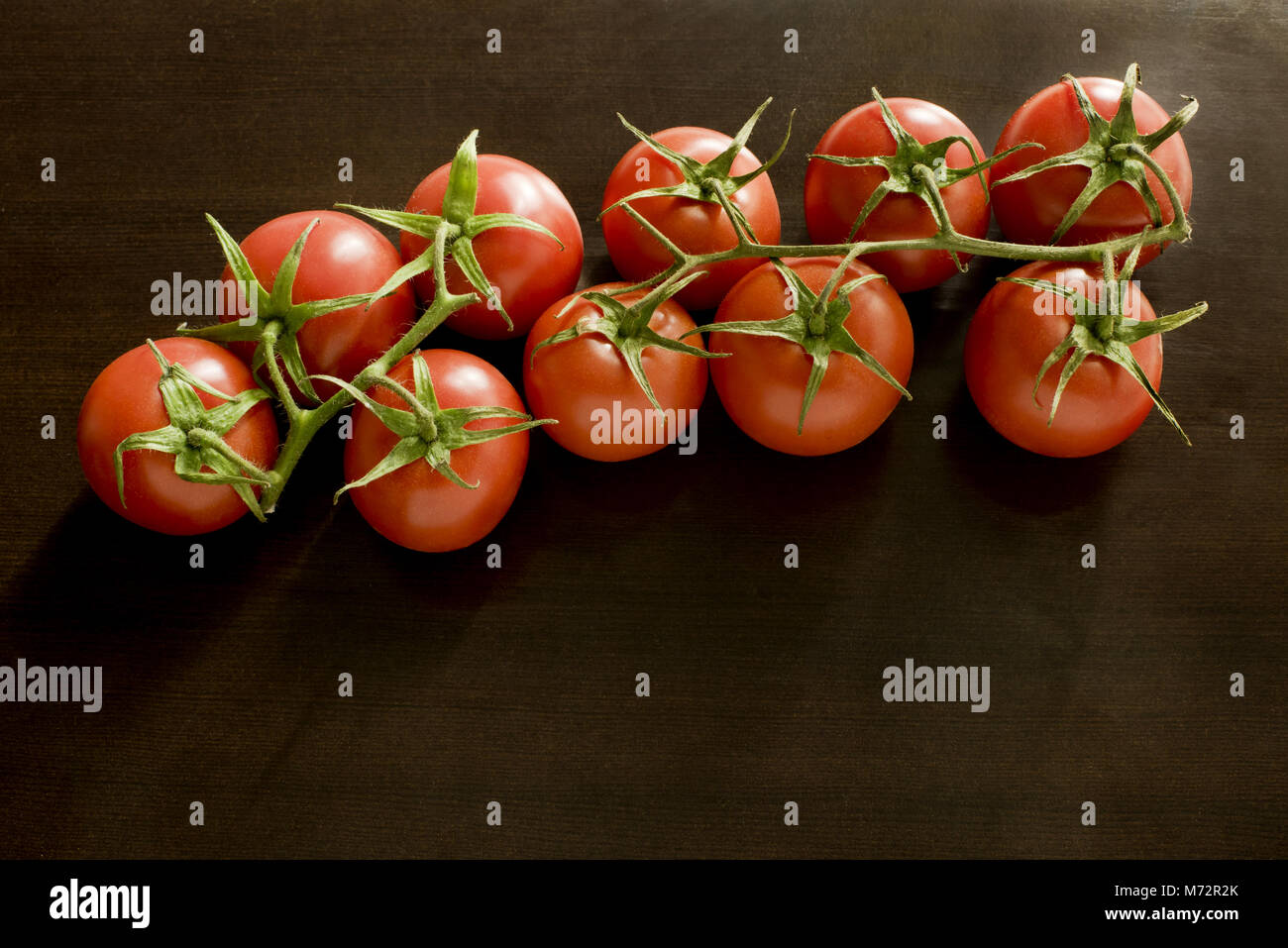 Bunch of small vine tomatoes on dark background - from above Stock ...