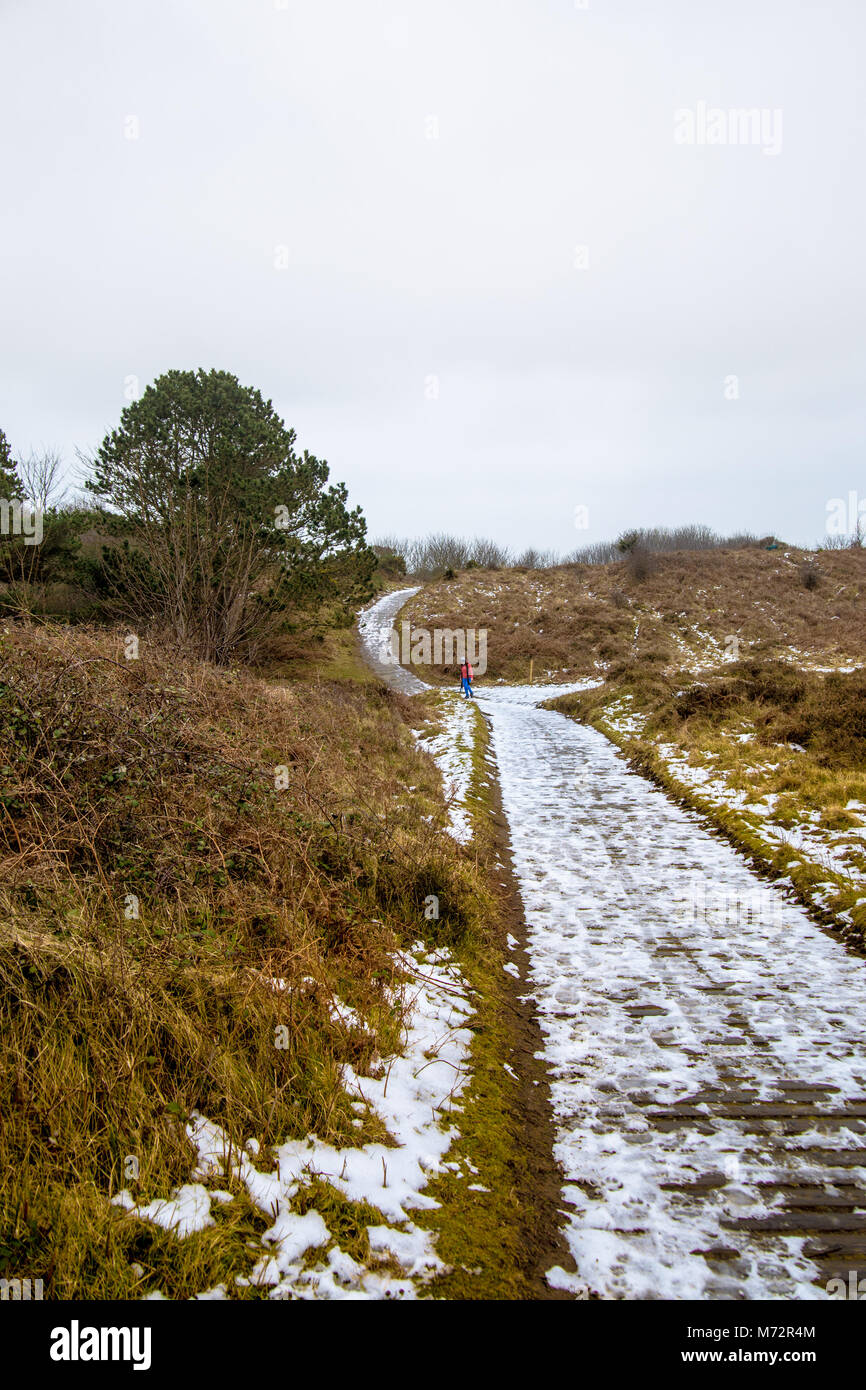 Small figure of a woman walking in snowy hills alone, photo from one ...