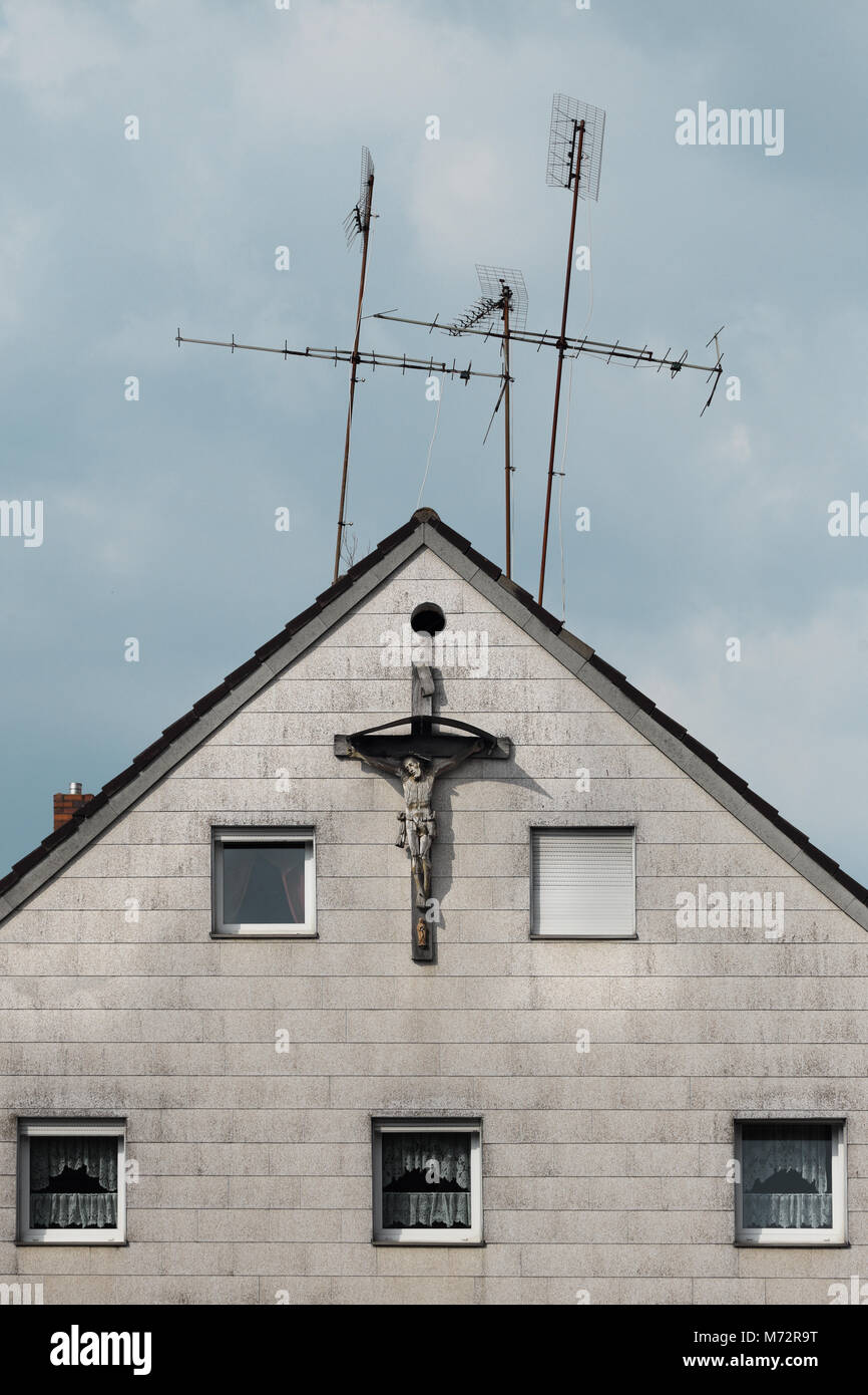 A crucifix is attached to a facade of a house in Franconia, Bavaria ...