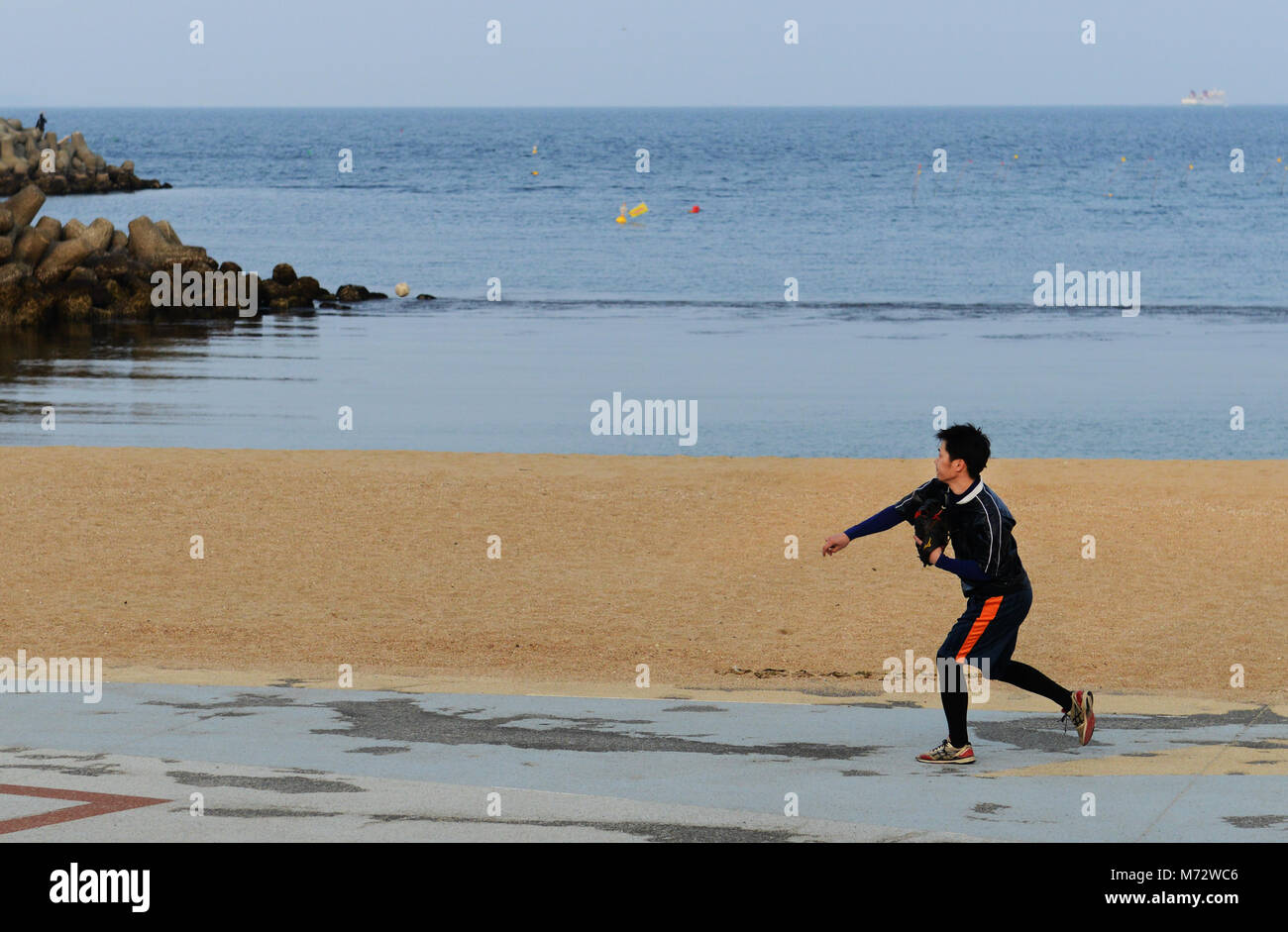 Japanese teenagers practicing baseball on the beach in Beppu, Japan ...